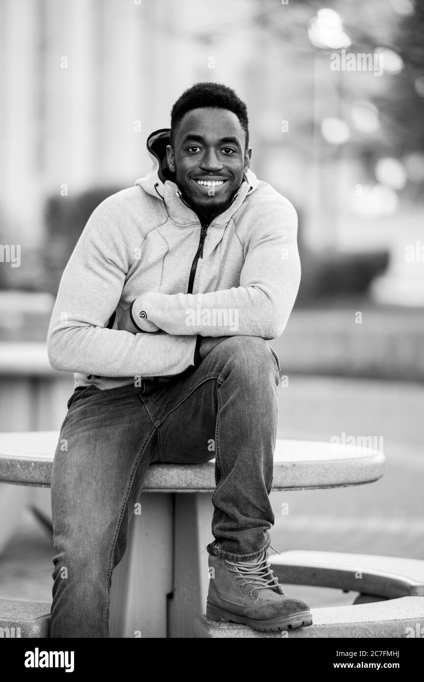 Vertical greyscale shot of an attractive African American male smiling ...