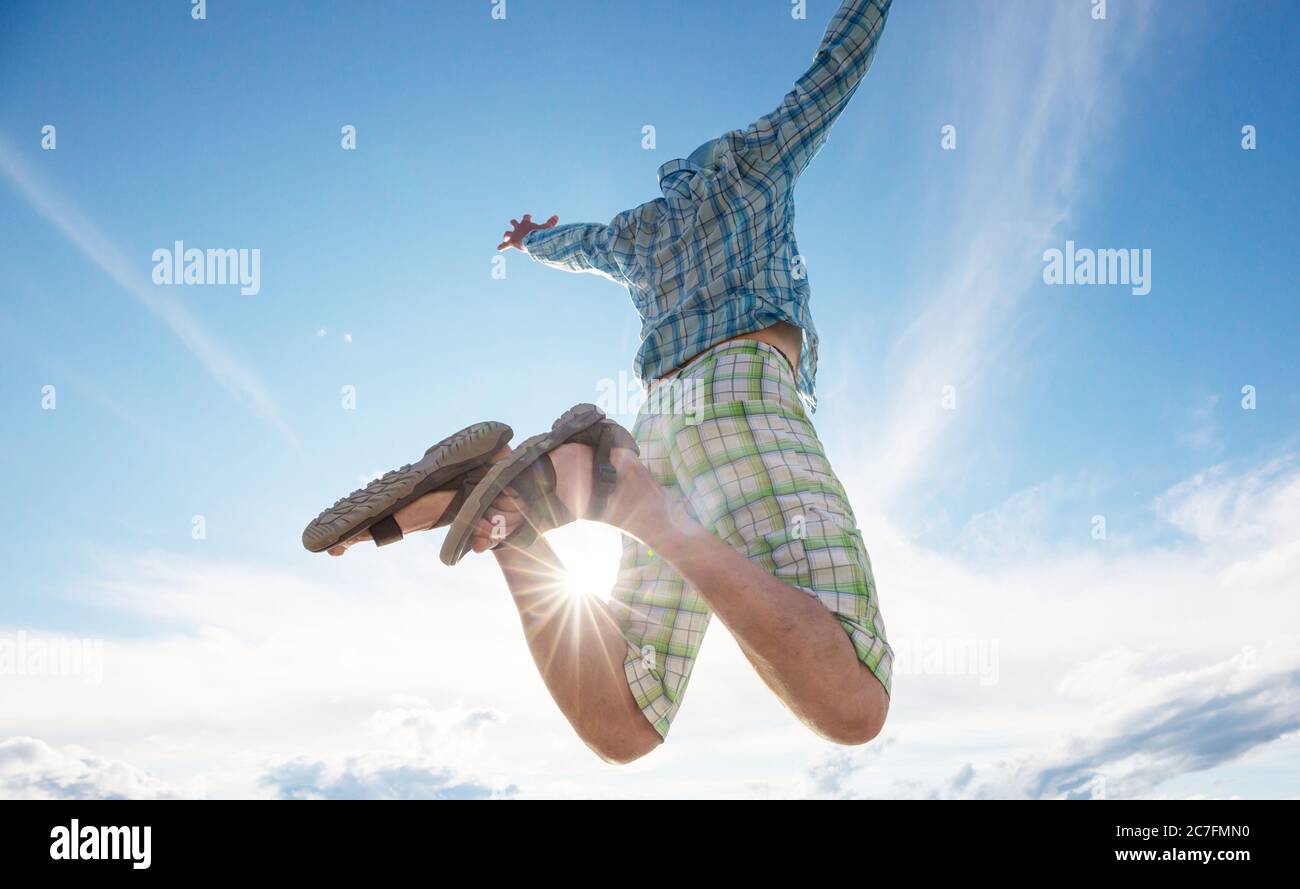 Jumping man in blue sky Stock Photo - Alamy