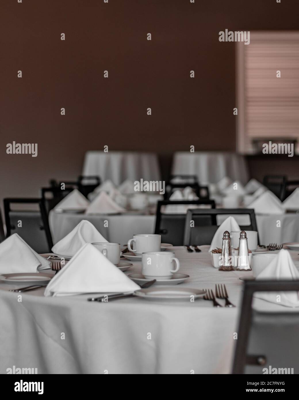 Vertical shot of neat tables in a nice, empty and clean restaurant ...