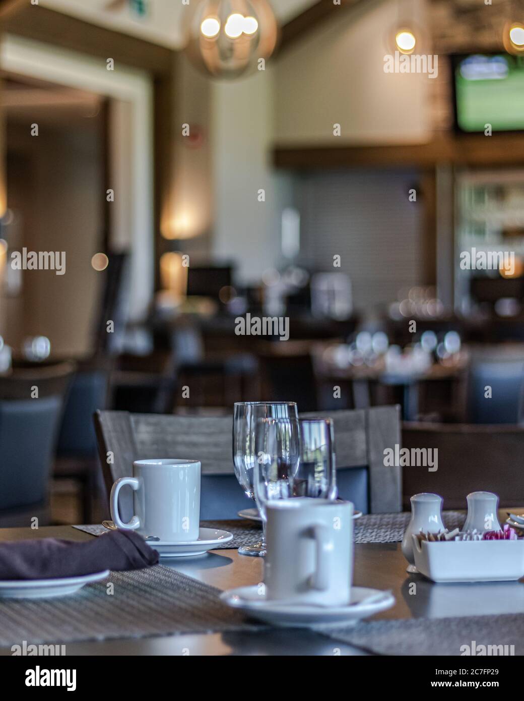 Vertical shot of neat tables in a nice, empty and clean restaurant ...