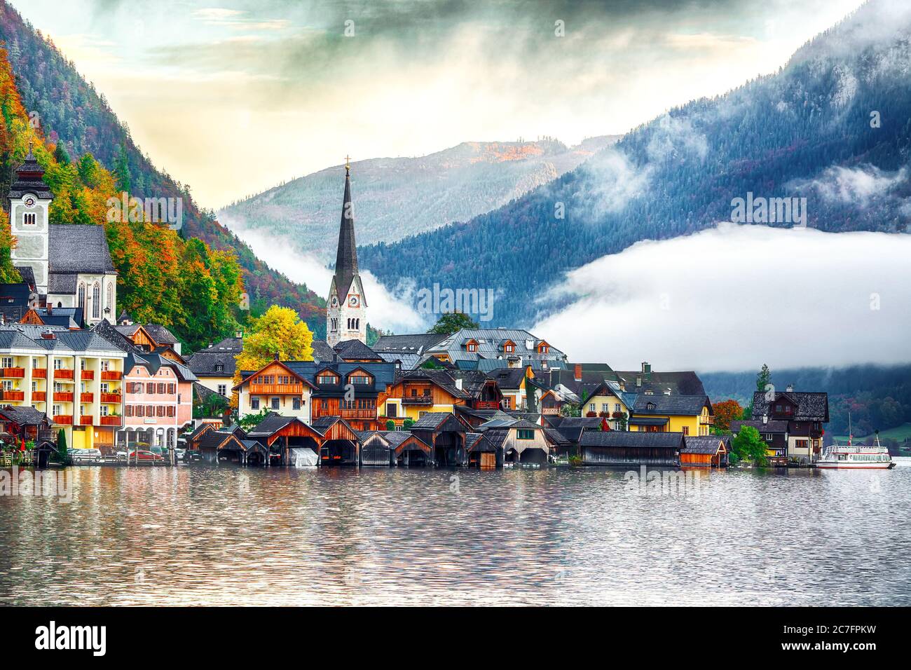 Scenic view of famous Hallstatt mountain village with Hallstatter lake. Foggy autumn sunrise on ...
