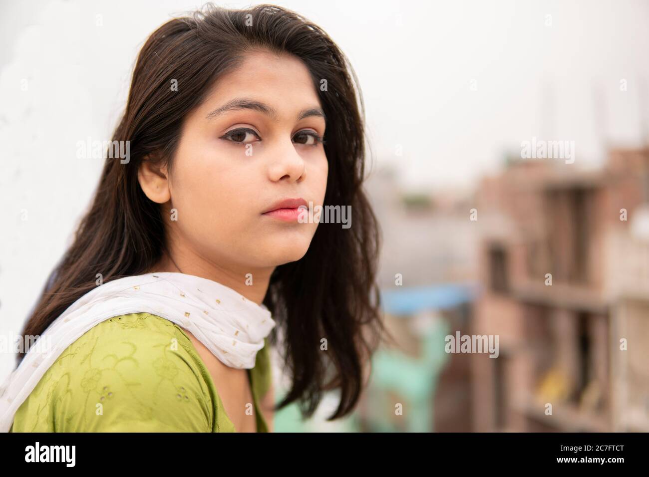 Outdoor close-up portrait of serene late teen girl looking at camera ...