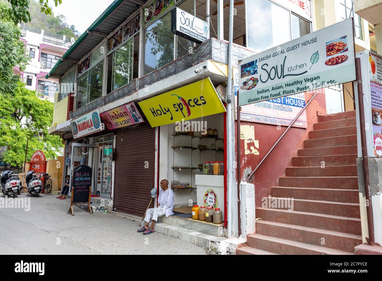 Several local shops on a narrow street in the holy town of Rishikesh on ...