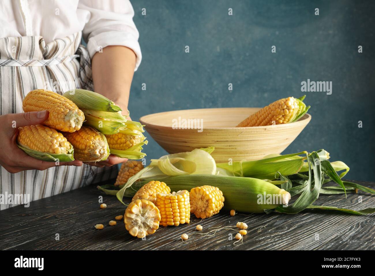 Woman with fresh corn against blue background Stock Photo - Alamy