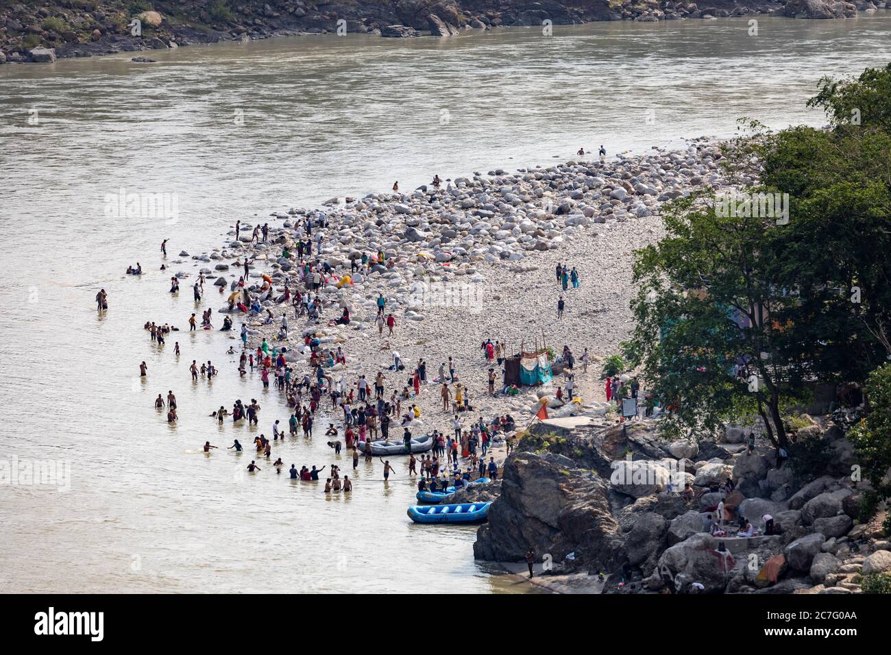 Tourists and devotees take a dip in the holy waters of the River Ganges ...