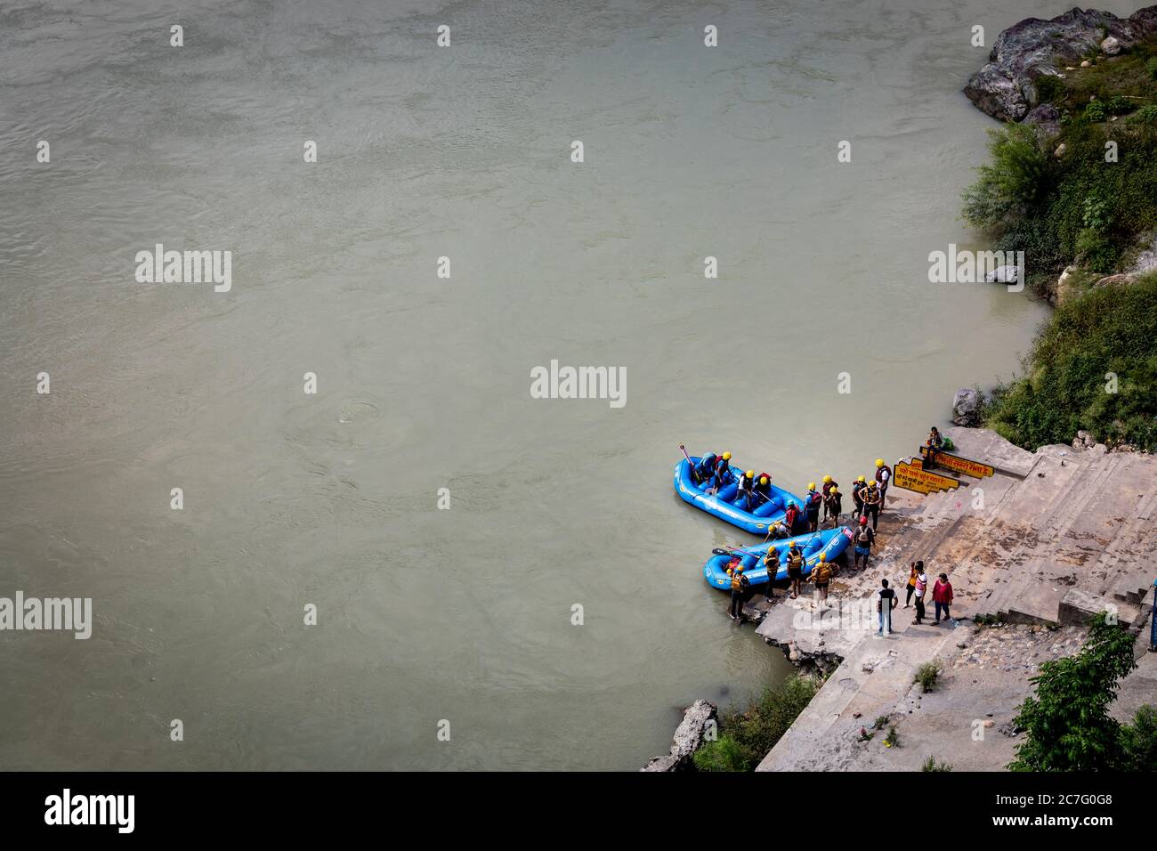 Tourists get onto a rafting boat on the banks of the River Ganges in ...