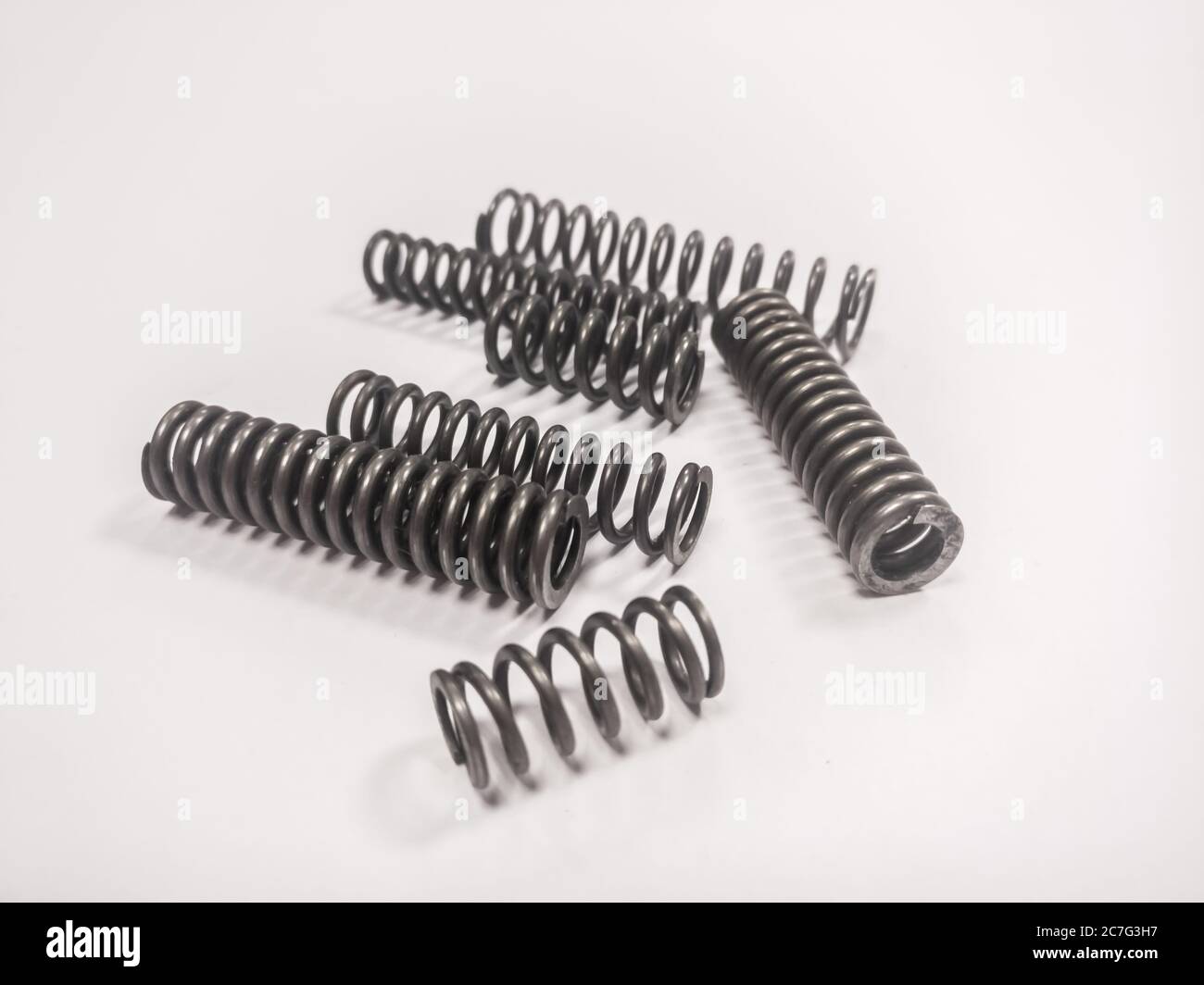 Lot of metal mainsprings on a white background Stock Photo - Alamy