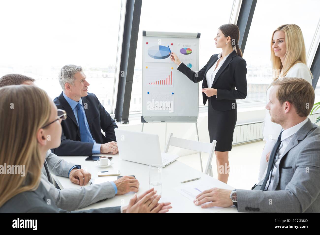 Business people giving presentation using financial diagrams at ...