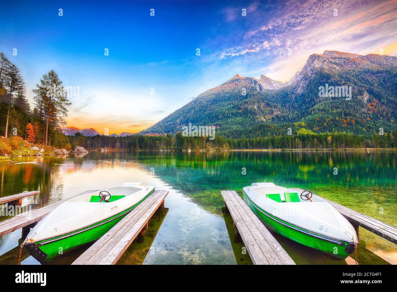 Fantastic autumn evening at Hintersee lake. Few boats on the lake with ...