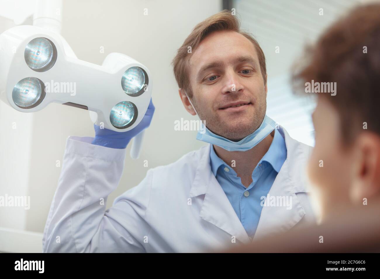 Cropped shot of a professional dentist adjusting dental lamp before ...