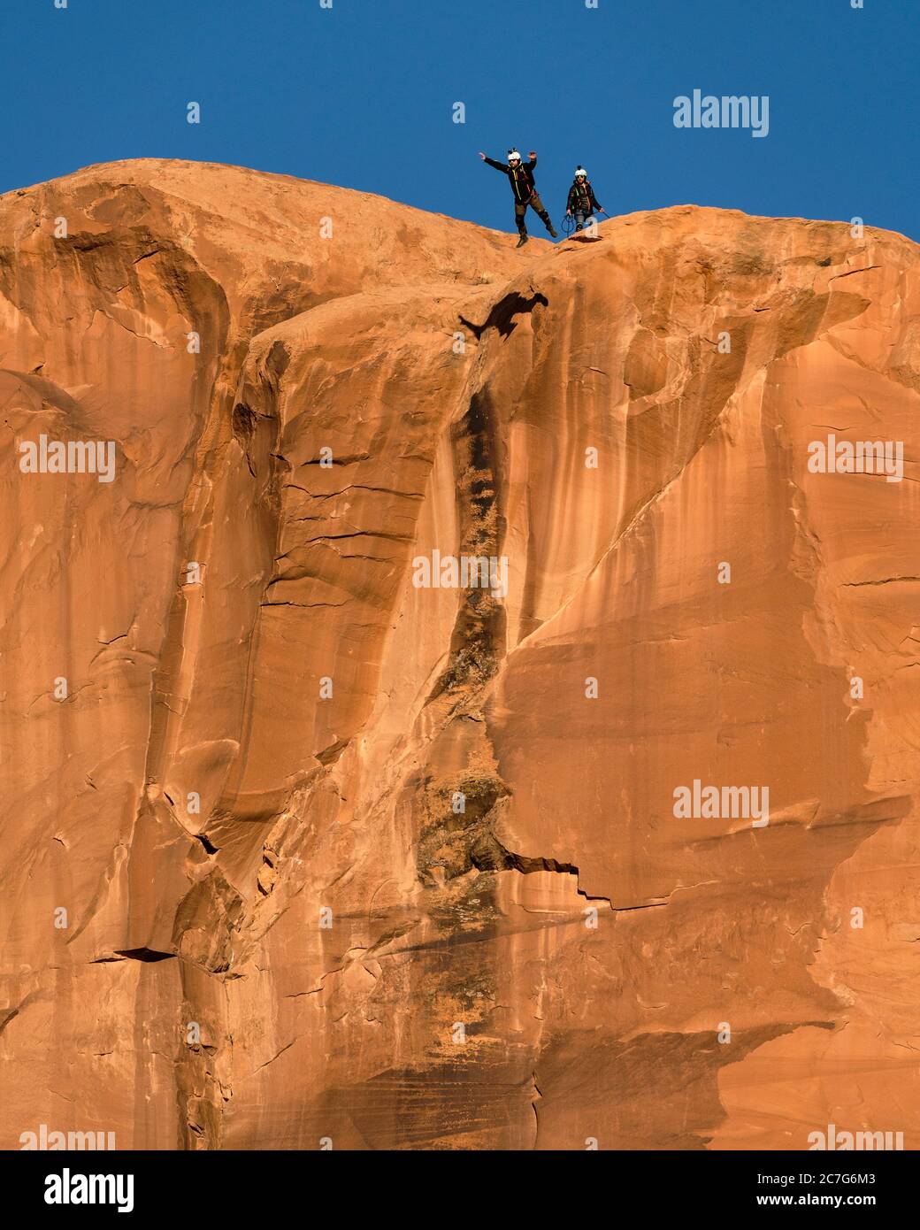USA, Utah, Moab, A base jumper leaps off the 400 foot vertical face of ...