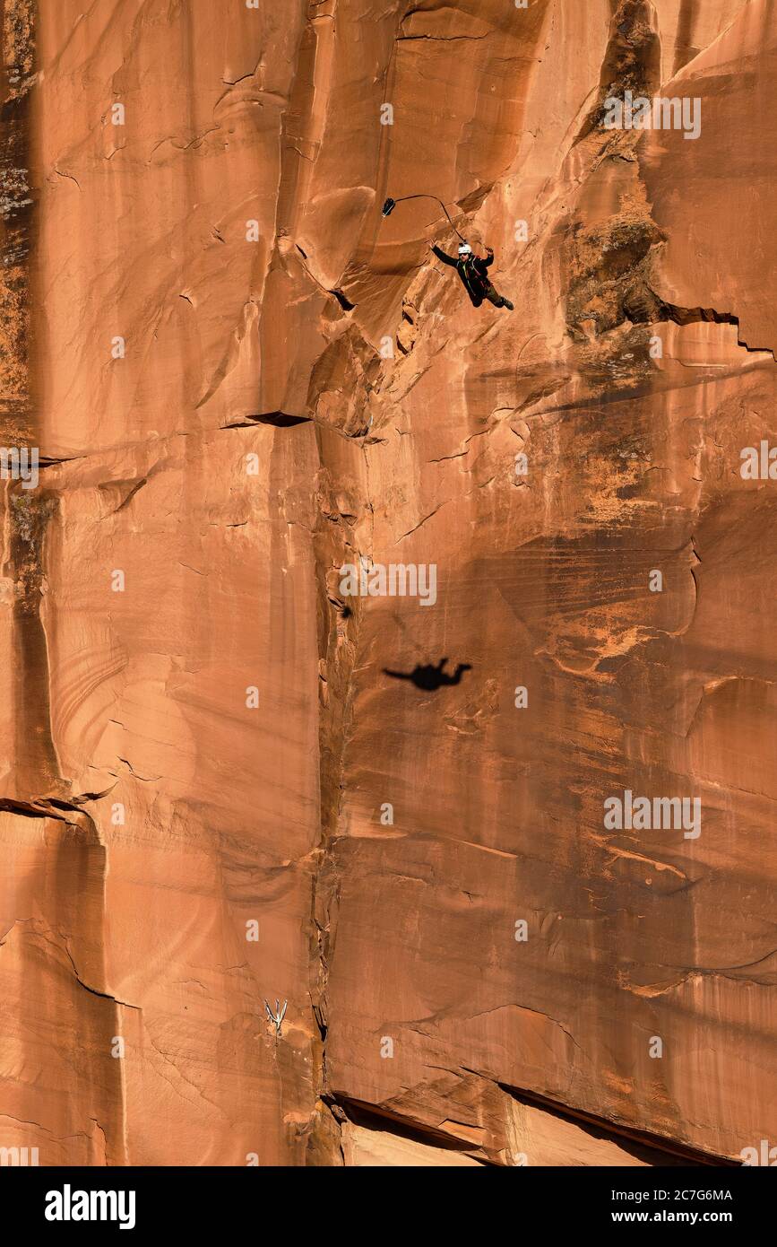 USA, Utah, Moab, A basejumper leaps off the 400 foot vertical face of ...