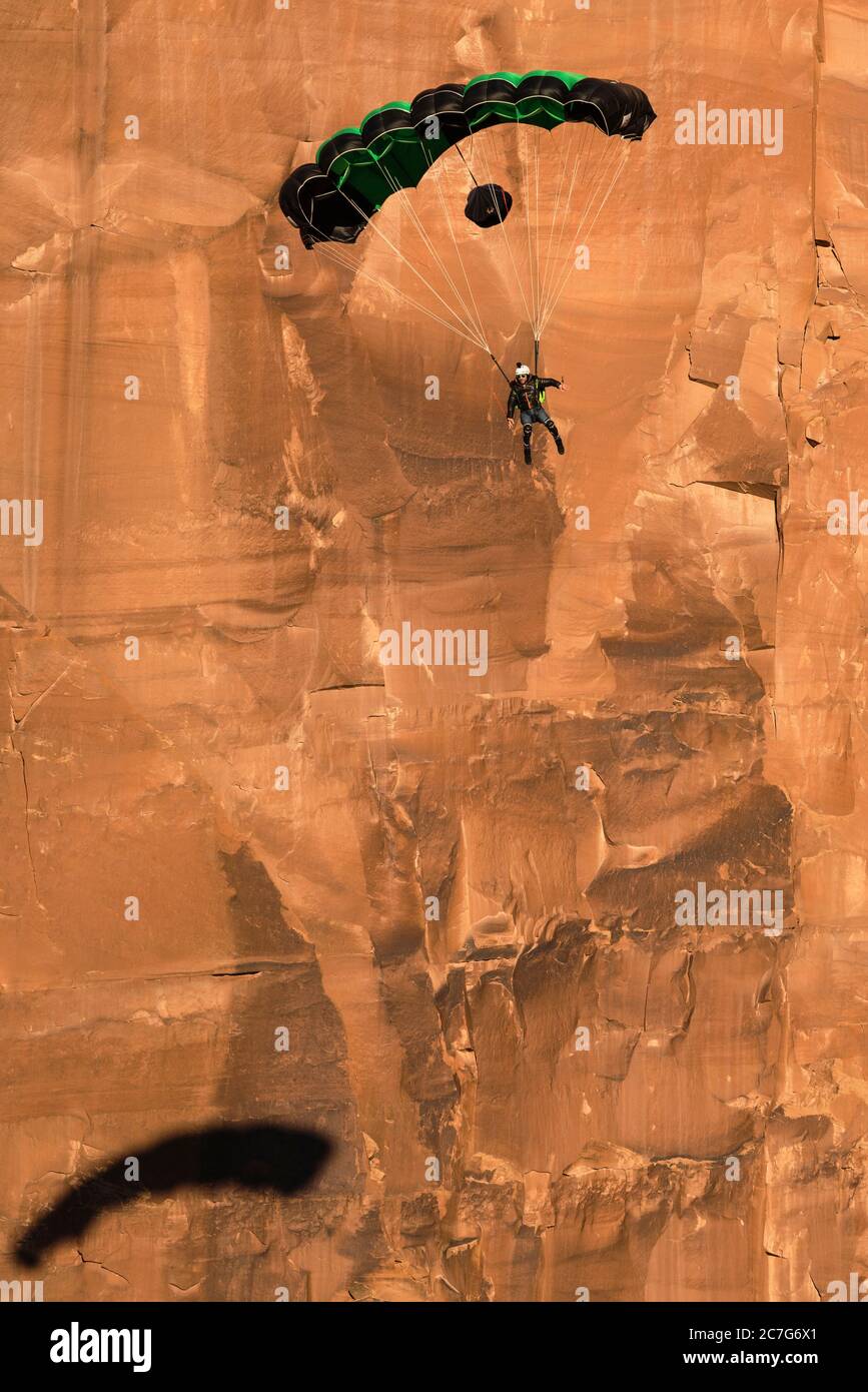 USA, Utah, Moab, A base jumper descends in his parachute off the 400 ...