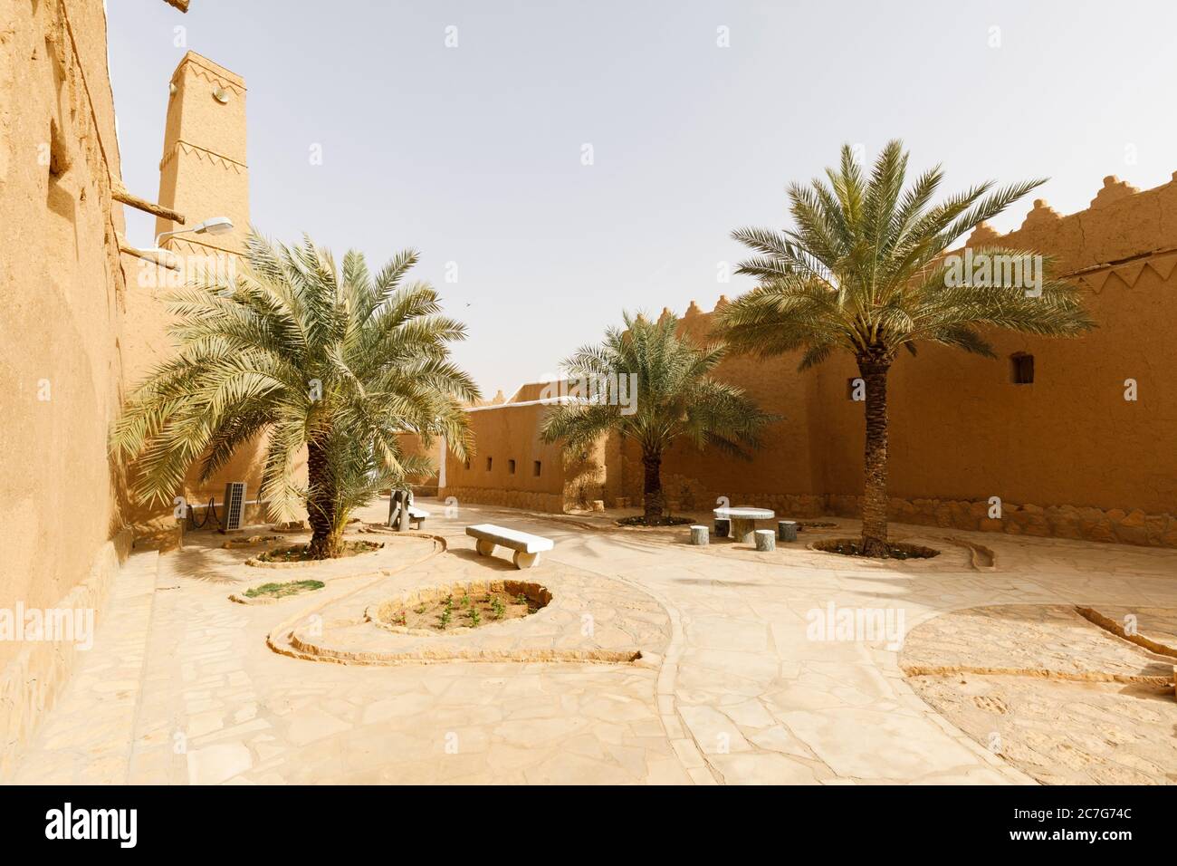 Public place with palm trees and renovated houses in the traditional ...