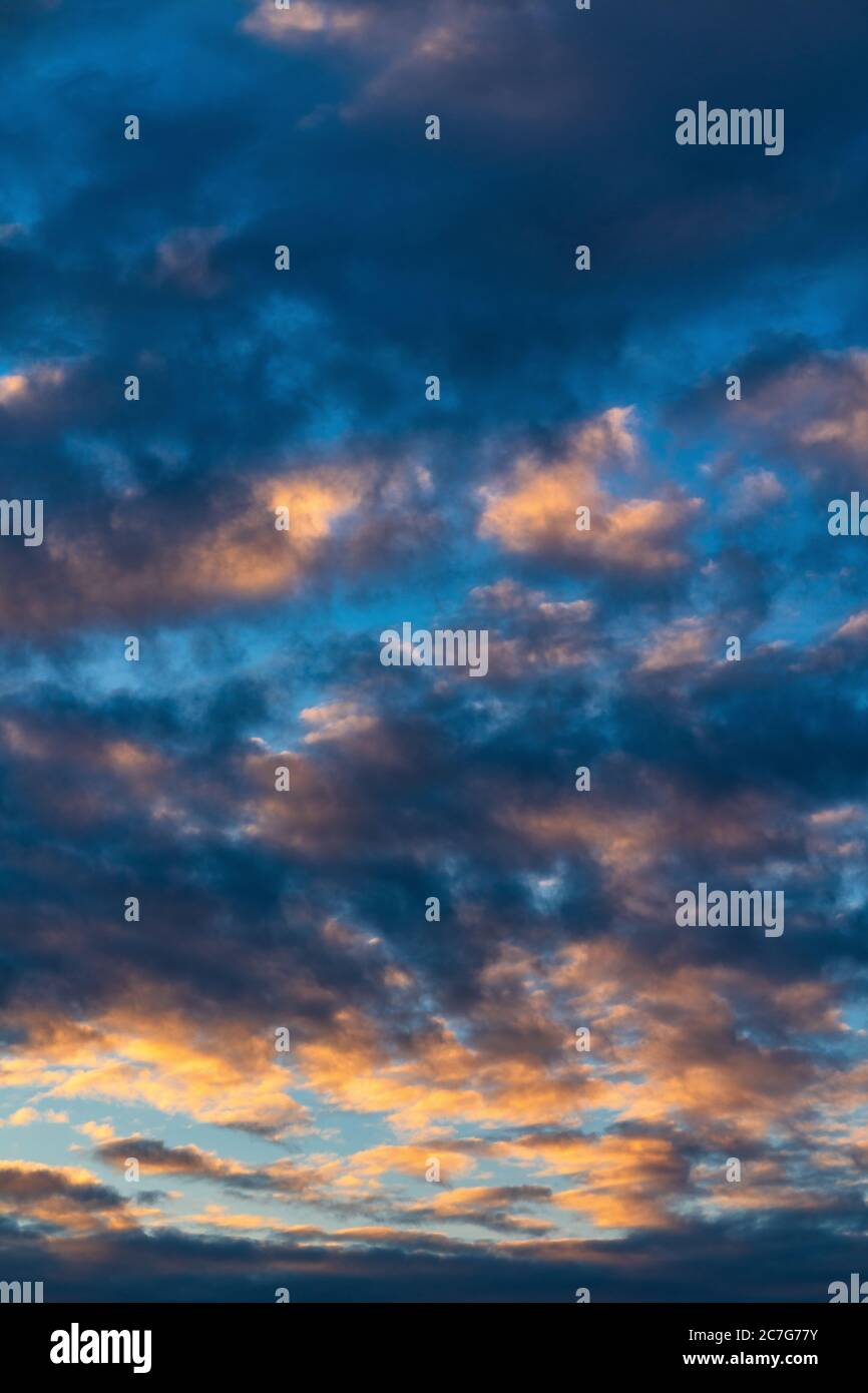 Beautiful clouds in blue sky, illuminated by rays of sun at colorful ...