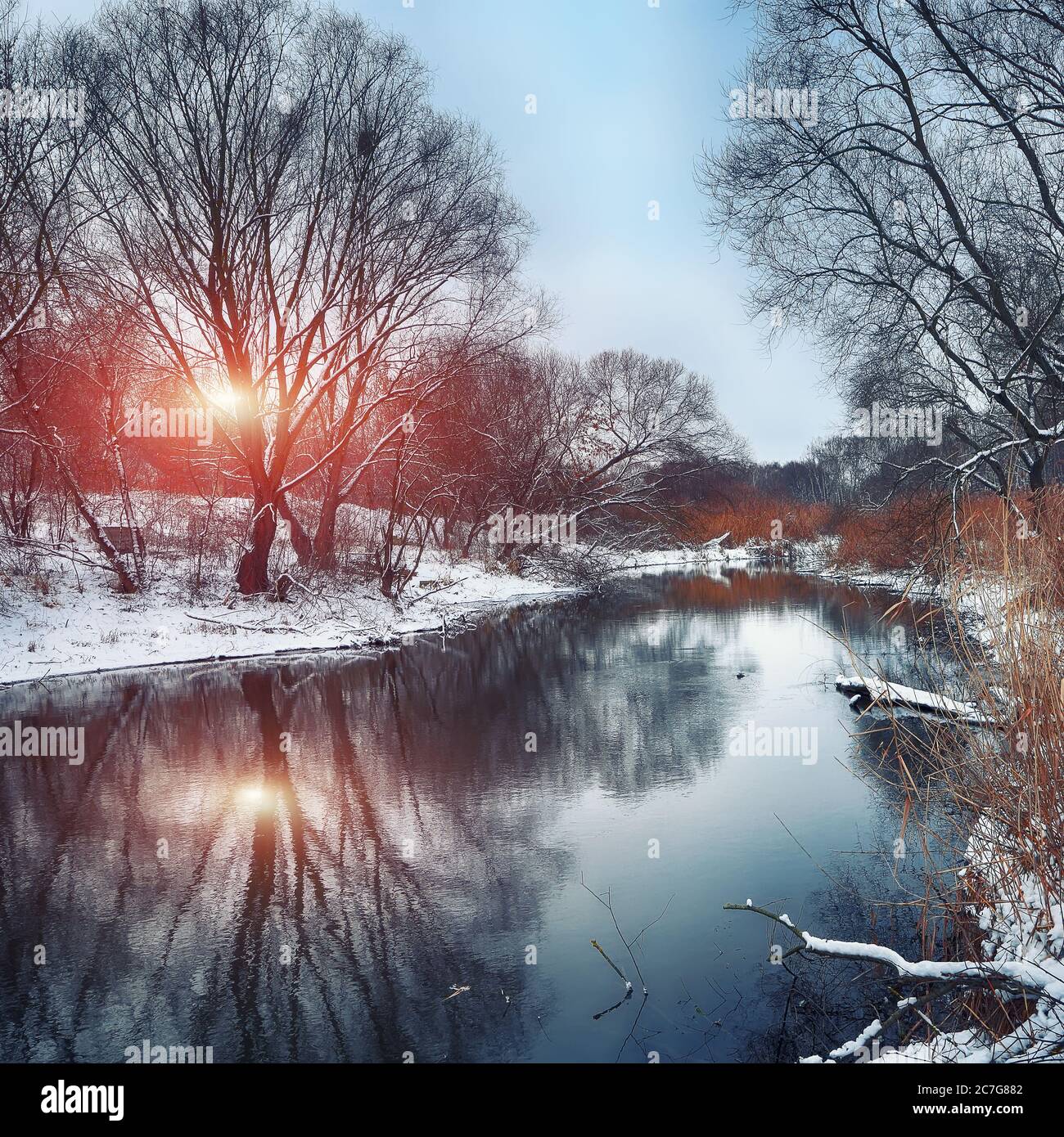 Winter landscape by a river in the sunset. Mirror reflection Stock ...