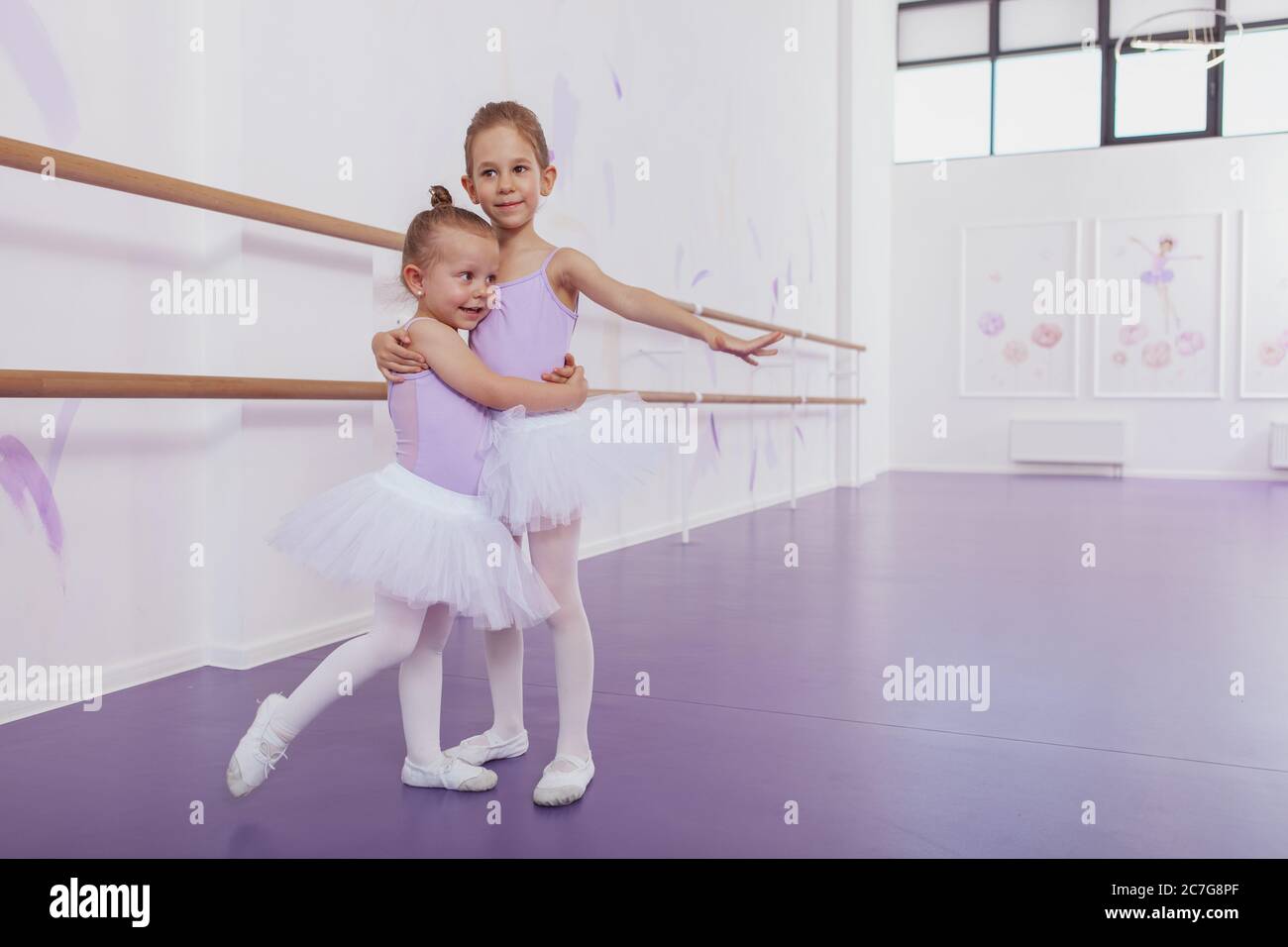 Happy cute little ballerinas having fun at dancing school, hugging ...