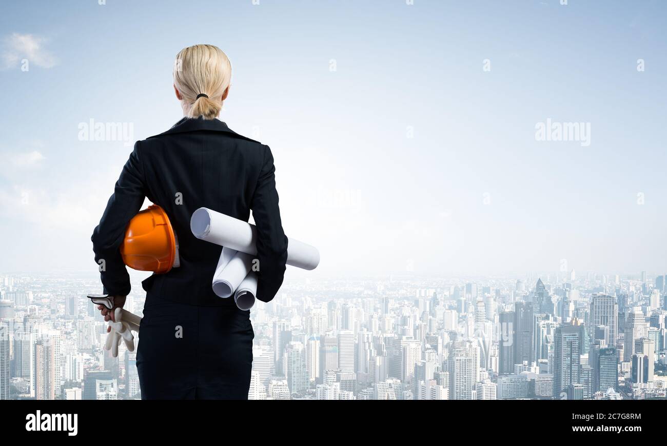 Architect standing with construction drawings Stock Photo - Alamy