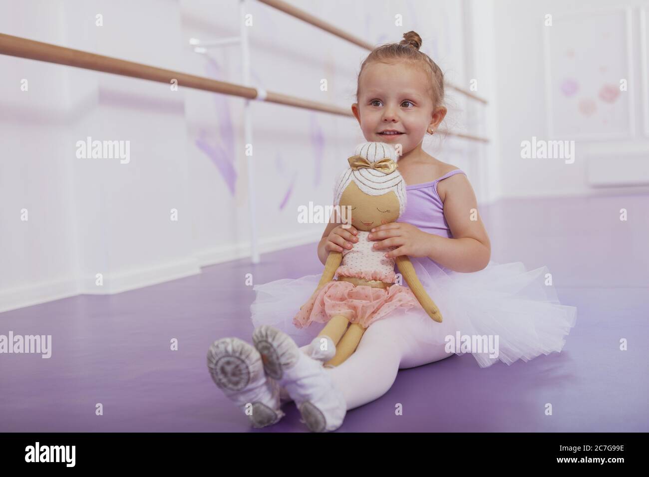 Charming little ballerina sitting on the floor at ballet class, copy ...