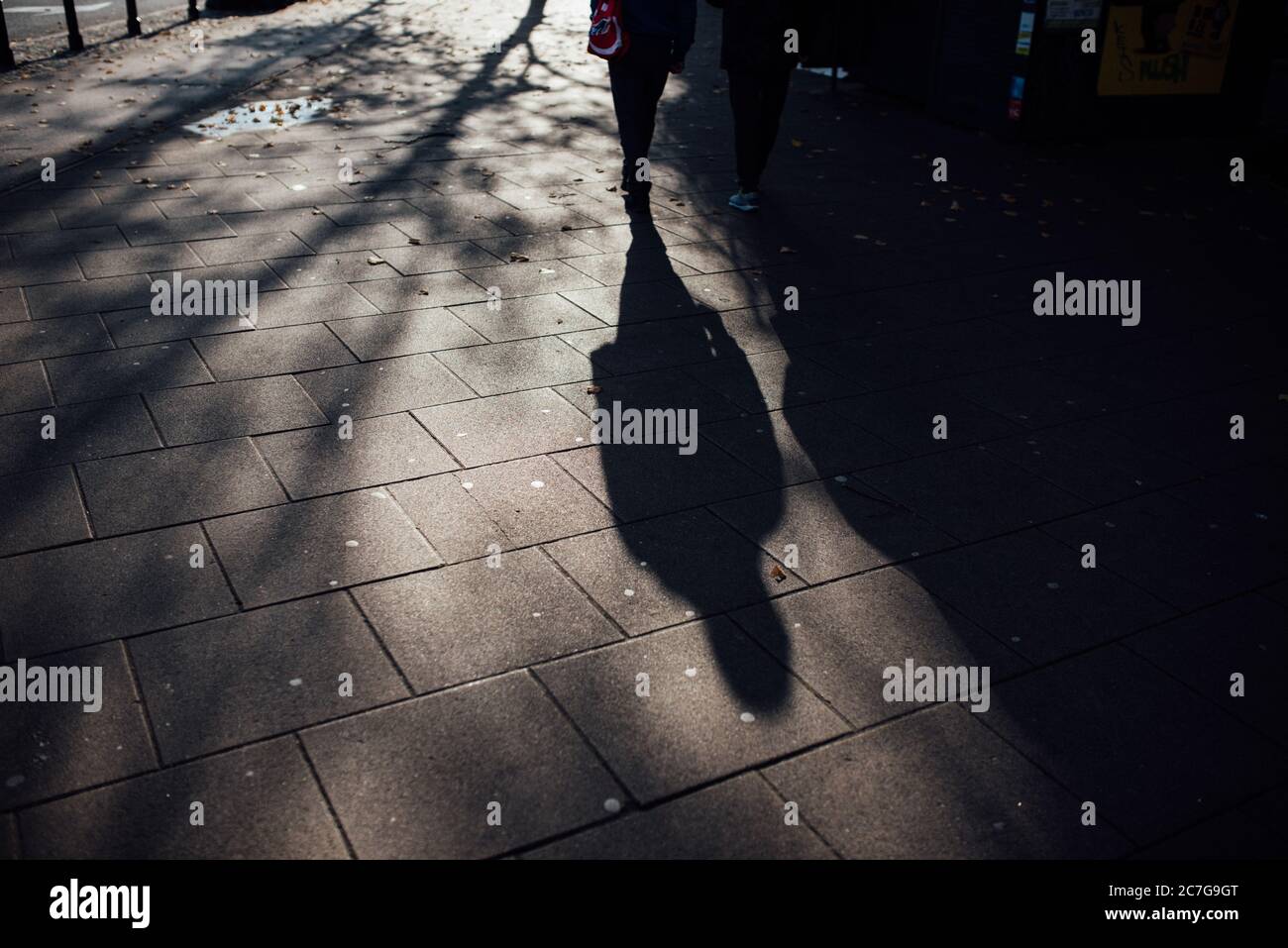Shadow of two people stretched on the pavement Stock Photo - Alamy