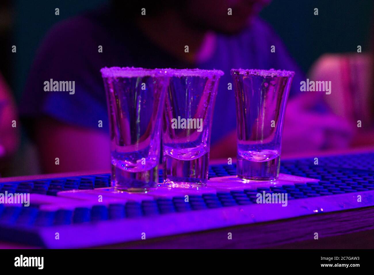 Tequila shots on the bar table, blue light and nightlife situation in ...