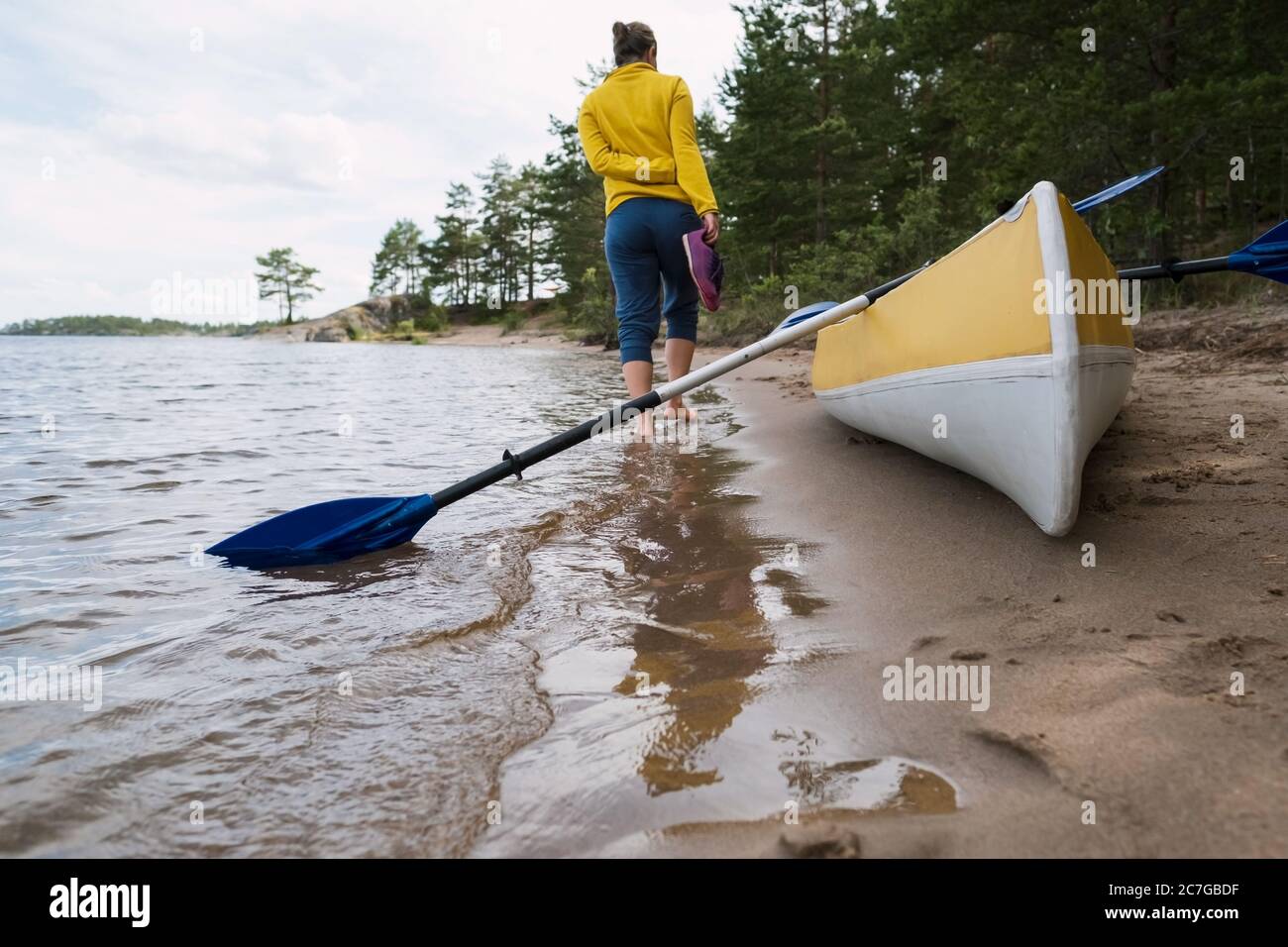 Woman traveler walking along the sandy beach near kayak Stock Photo - Alamy