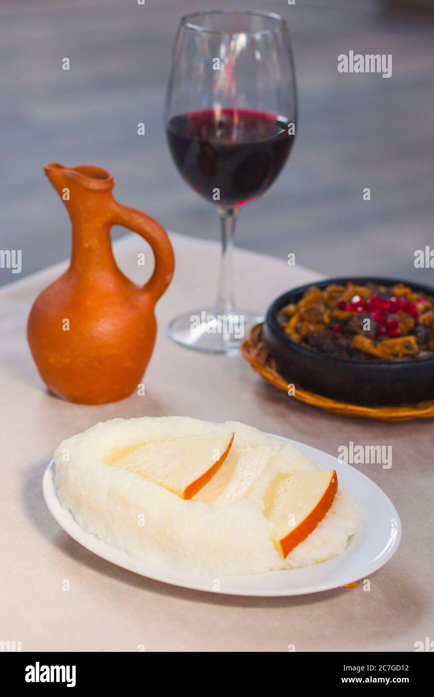 Georgian traditional food ghomi with cheese, wine and kuchmachi ...