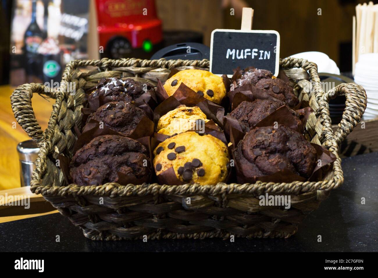 Large group of muffins in wooden bowl with chocolate and name letter ...
