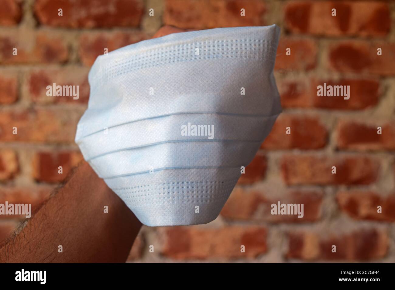 Medical surgical face mask on hand front of bricks wall background ...