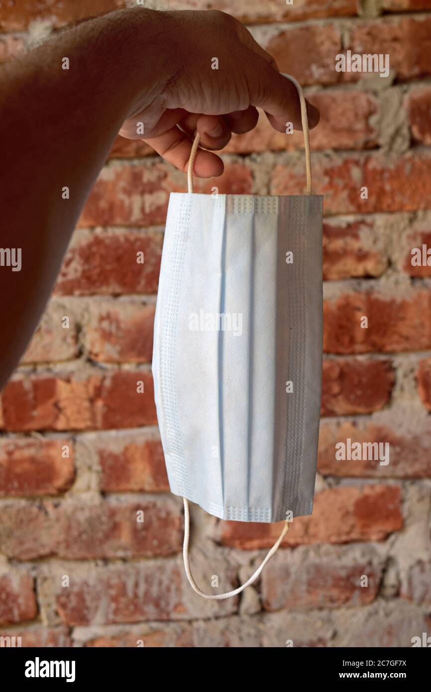 Medical surgical face mask on hand front of bricks wall background ...