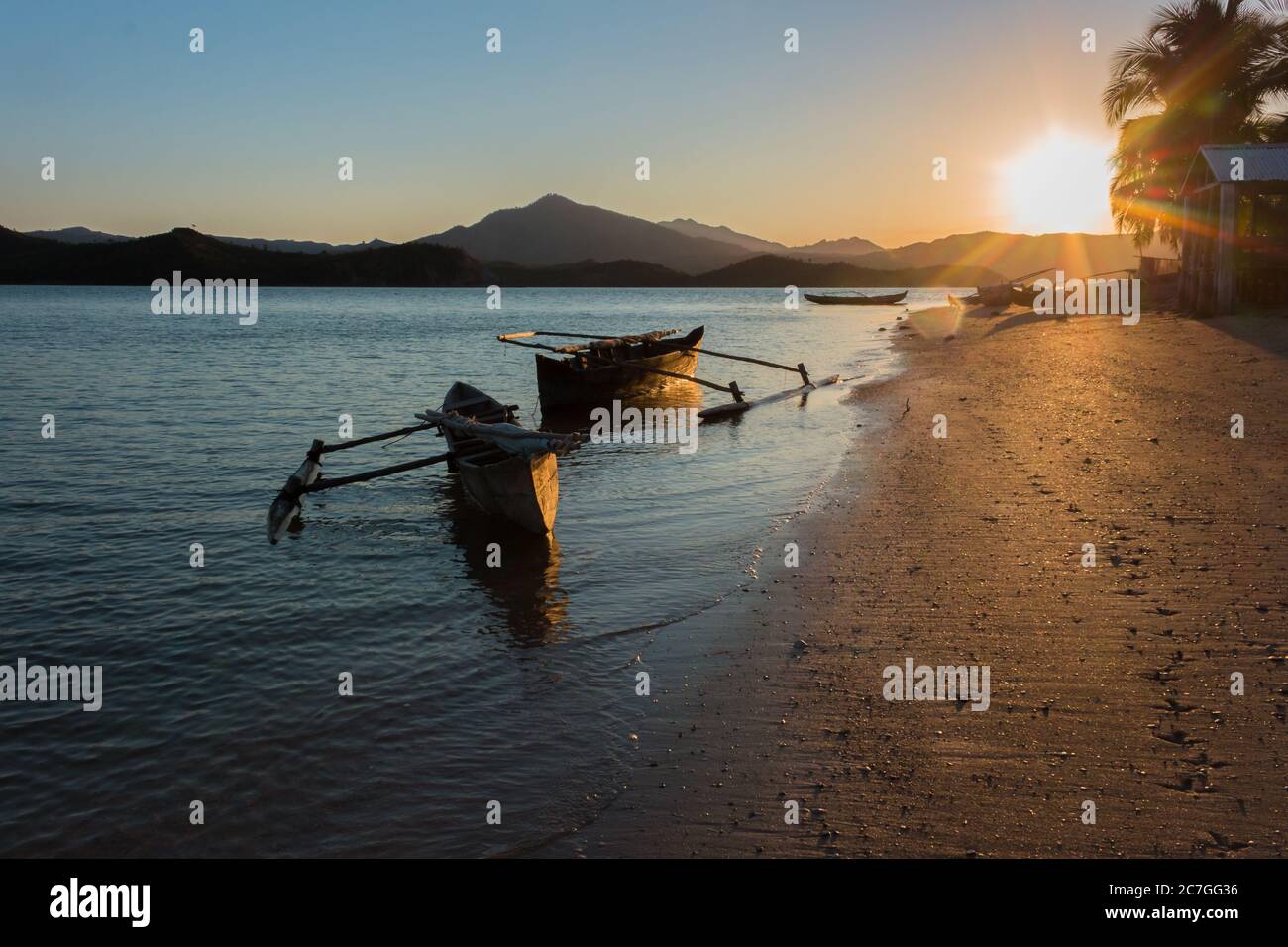 View of Nosy Komba Island coastline with a traditional wooden boat on ...