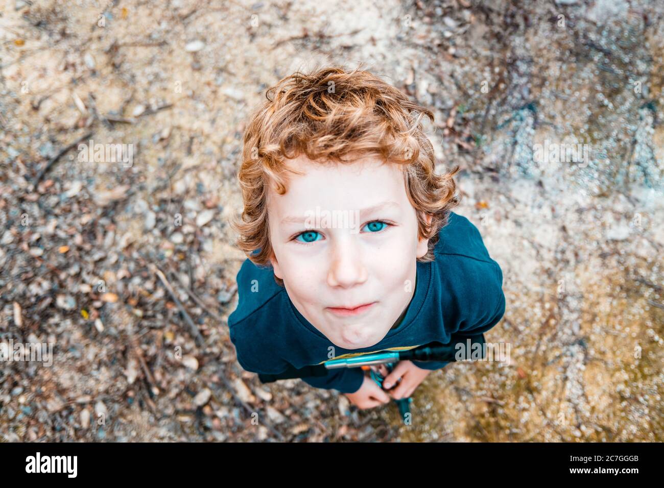 Blond boy making funny gestures and faces photographed from above with ...