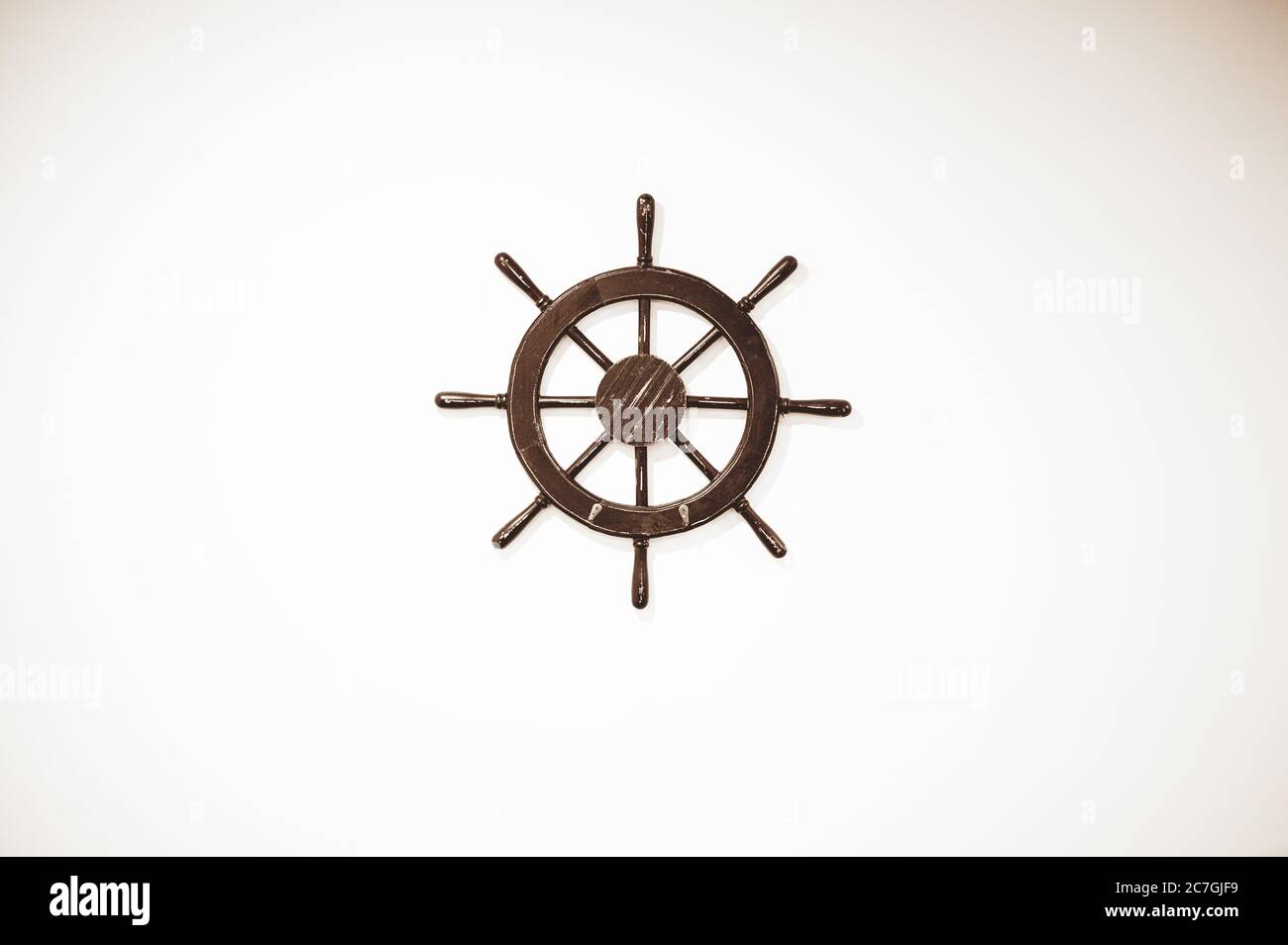 High angle shot of a small wooden ship's helm on a white surface Stock ...