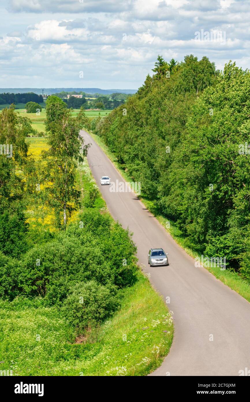 Cars on a road in a country landscape Stock Photo - Alamy