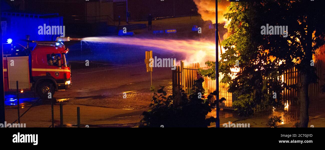 Wide shot of a fire truck putting out a fire Stock Photo - Alamy