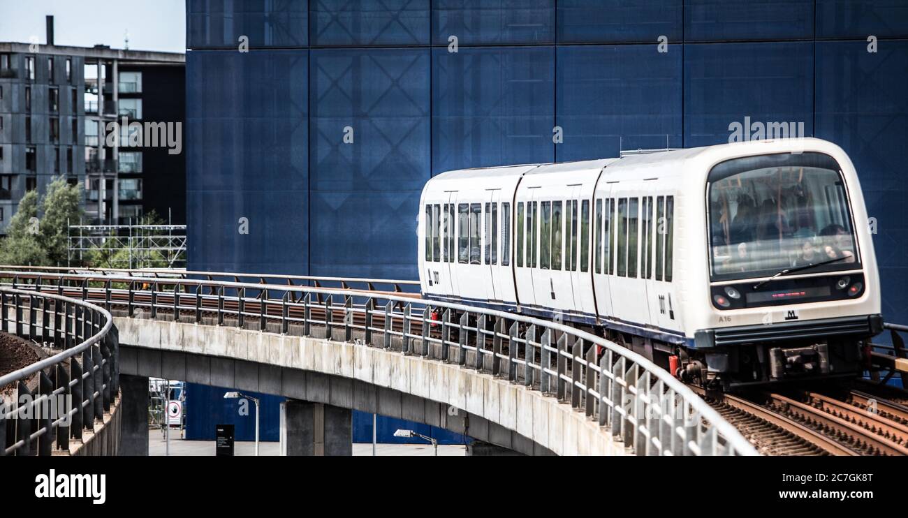 Metro on tracks in the middle of city buildings Stock Photo - Alamy