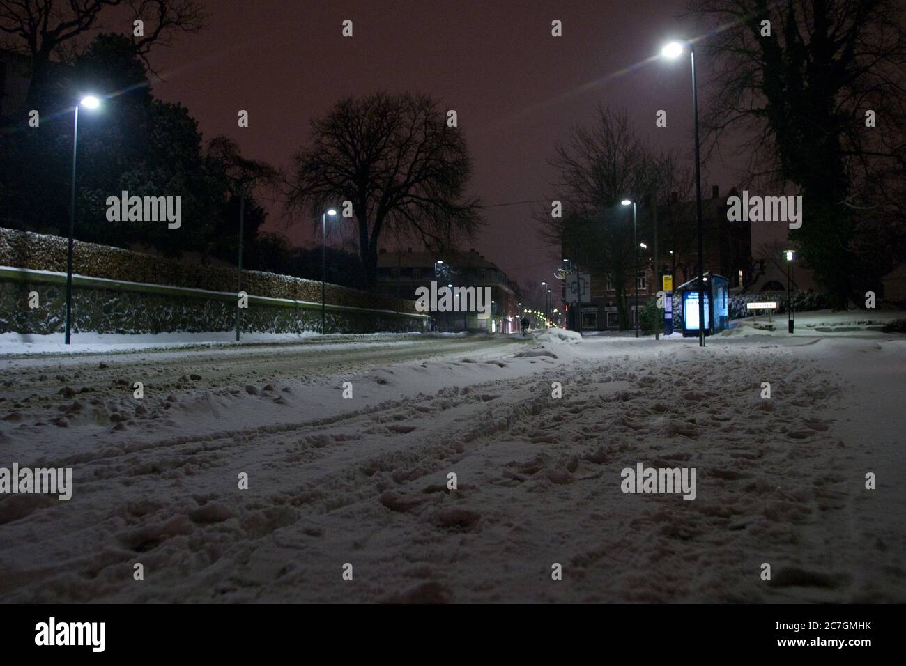 Snow-covered street with lit lights at night time Stock Photo - Alamy