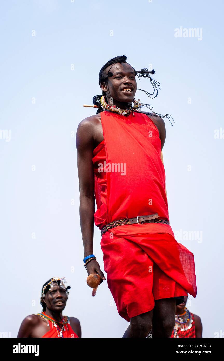 Maasai man smiling wearing traditional attire, taking part in the ...