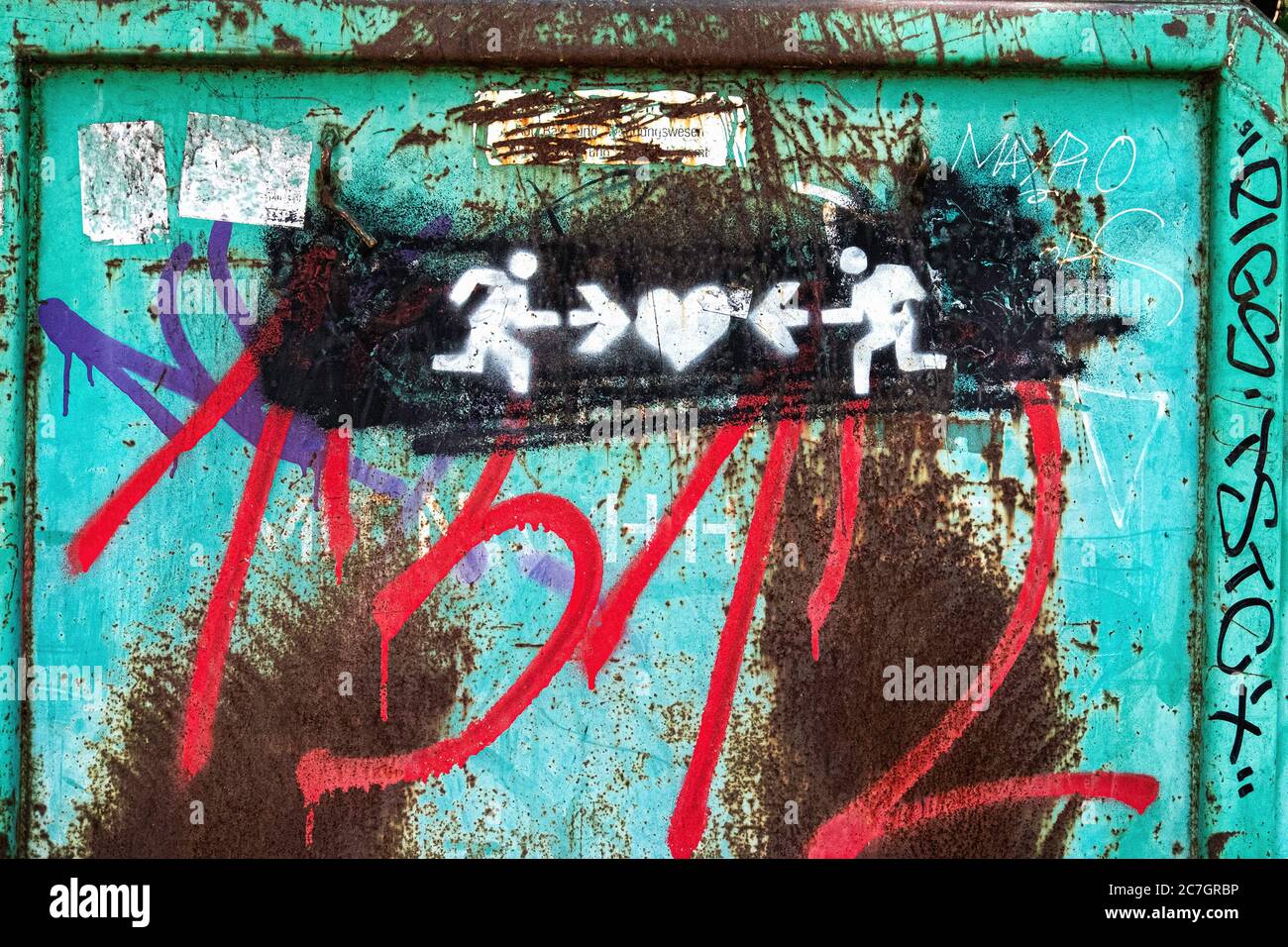 Rusty old skip with little stencil of two people running towards a ...
