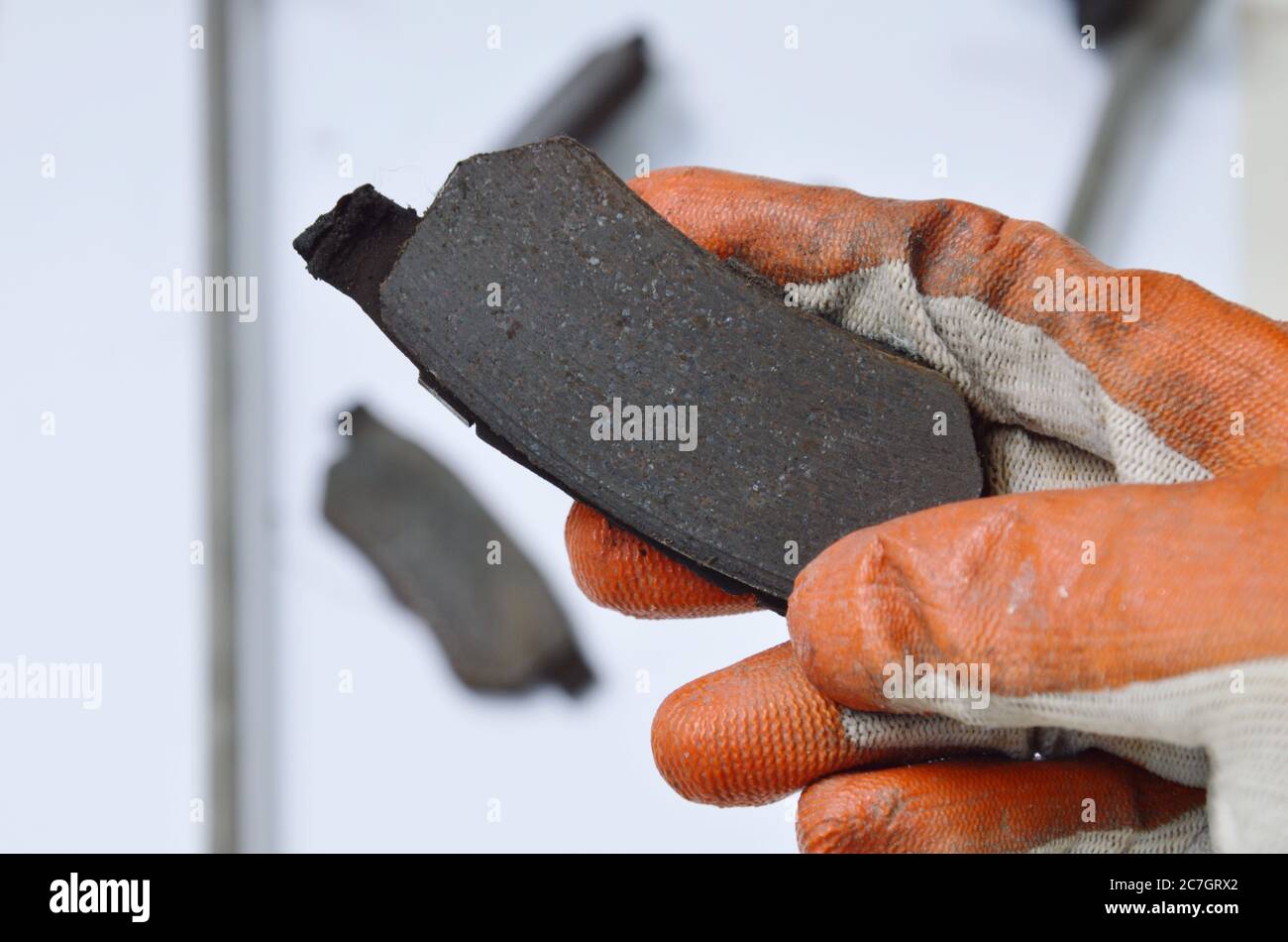 hand in glove holding invalid brake lining for changed on wheel ...