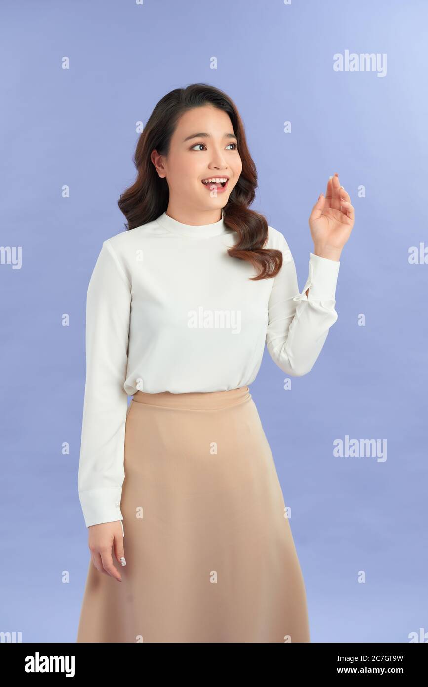 Attractive friendly looking young woman smiling happily, saying Hello ...