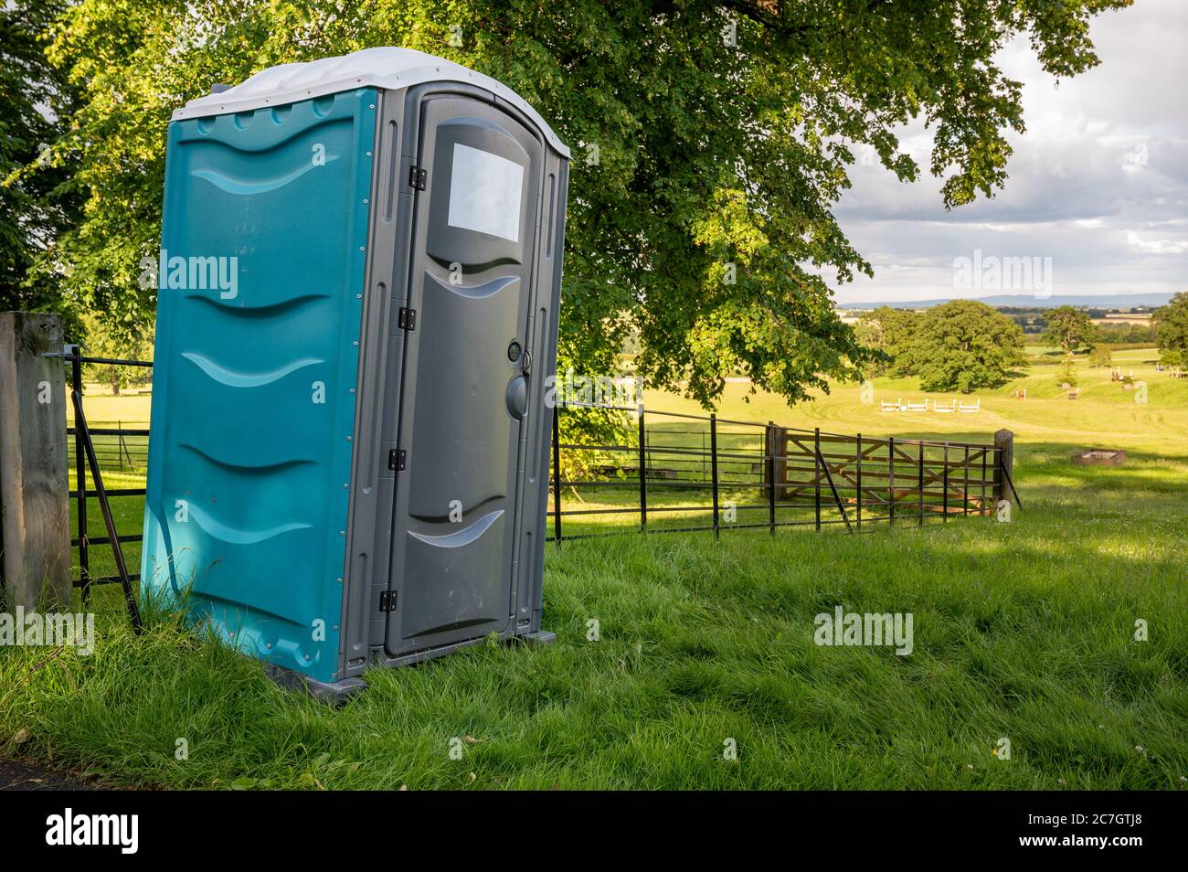A plastic portable toilet in a field at an outdoor cross country horse ...