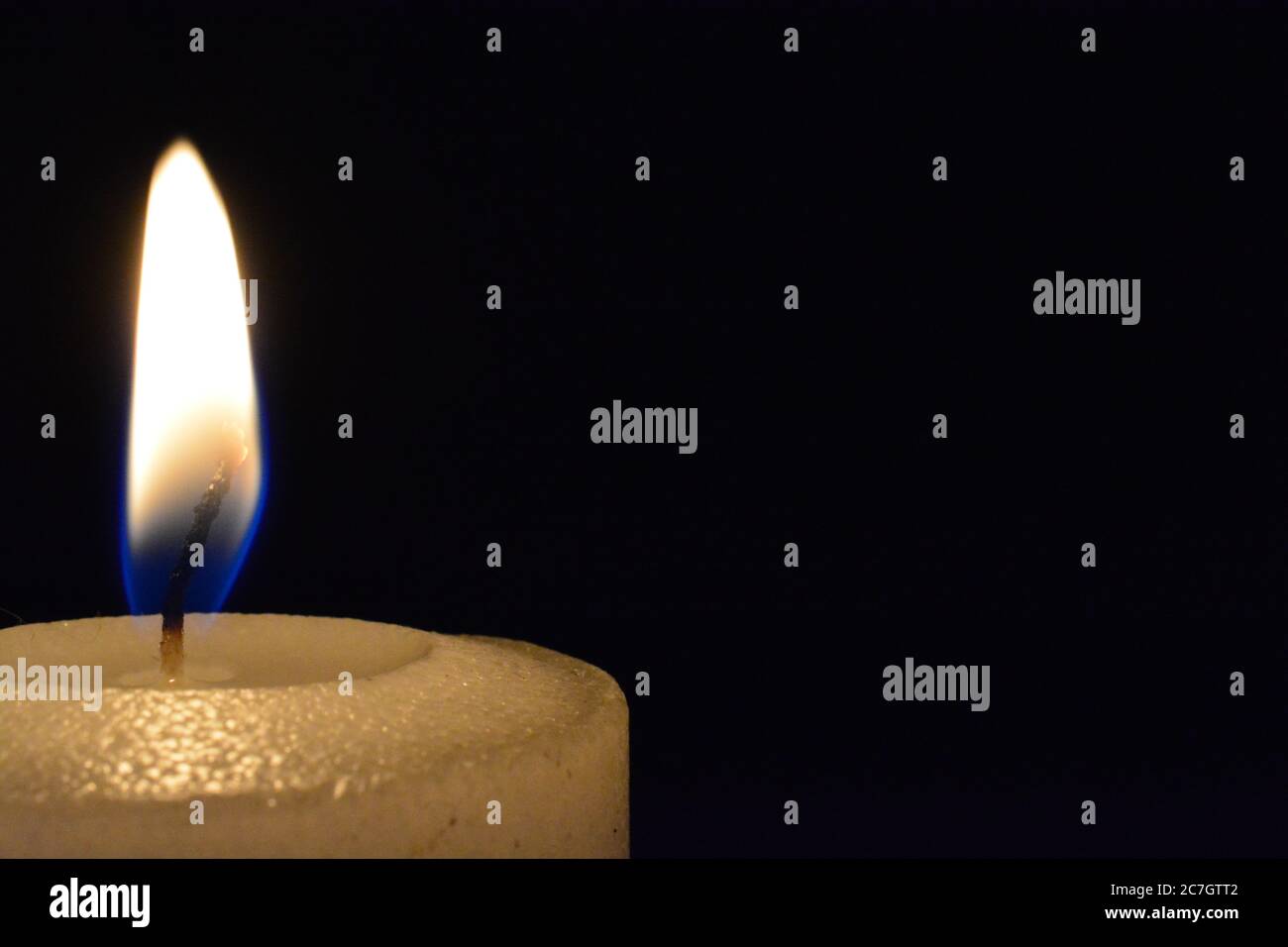 Closeup of a lighten candle against a black background - a nice picture ...