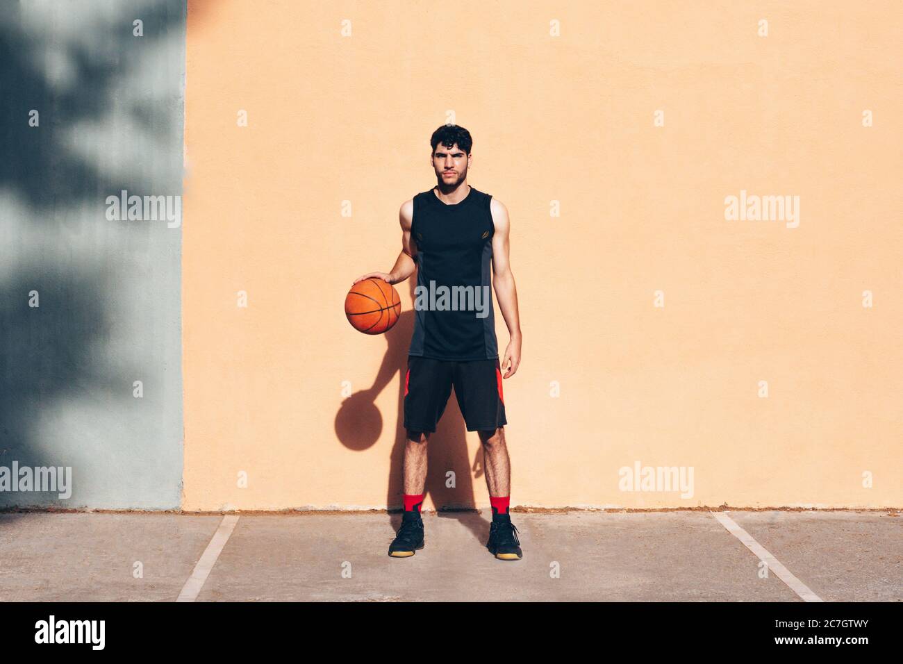 basketball player with the ball in front of a wall Stock Photo - Alamy
