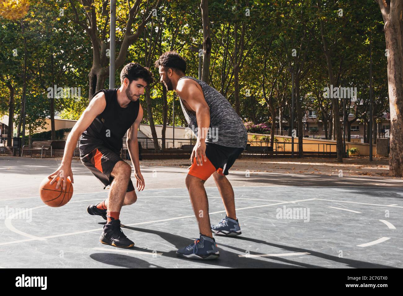 two young men playing basketball outdoors fight for the ball Stock ...