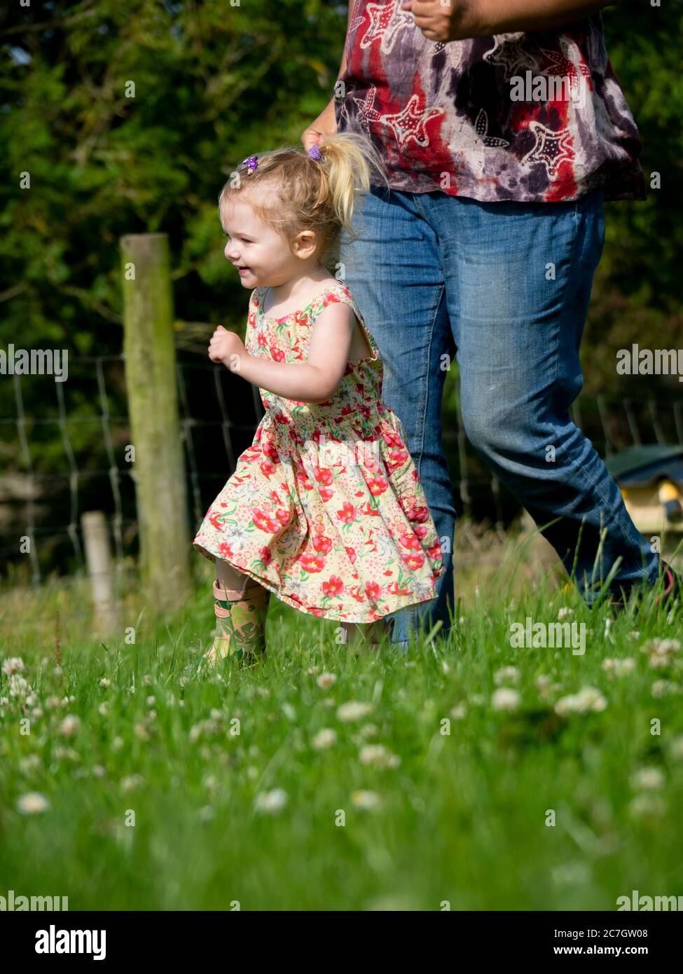 Toddler playing chase with adult, UK Stock Photo - Alamy