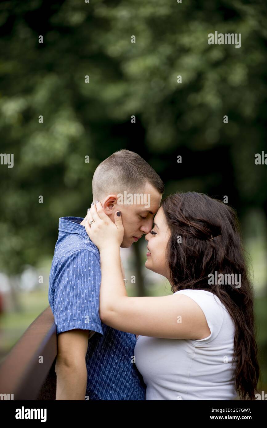 Vertical shot of a couple holding each other near the beautiful trees ...