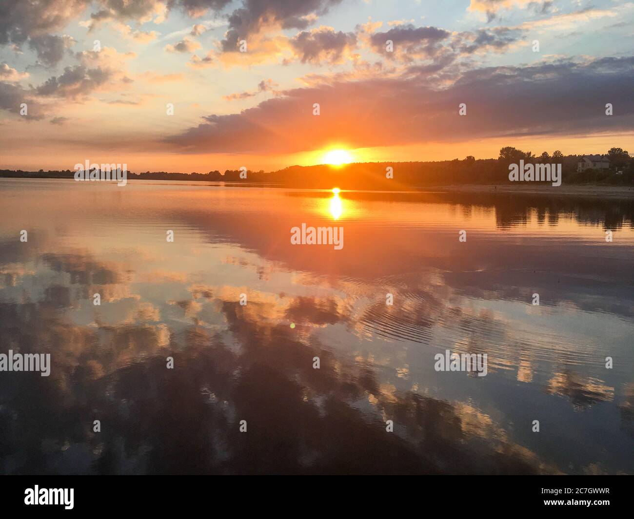 Beautiful bright and colorful summer sunset reflection with clouds ...