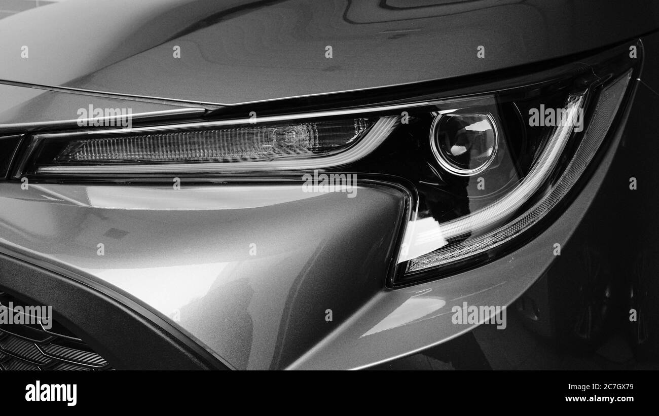 Greyscale closeup of a grey modern car headlight under the lights Stock ...