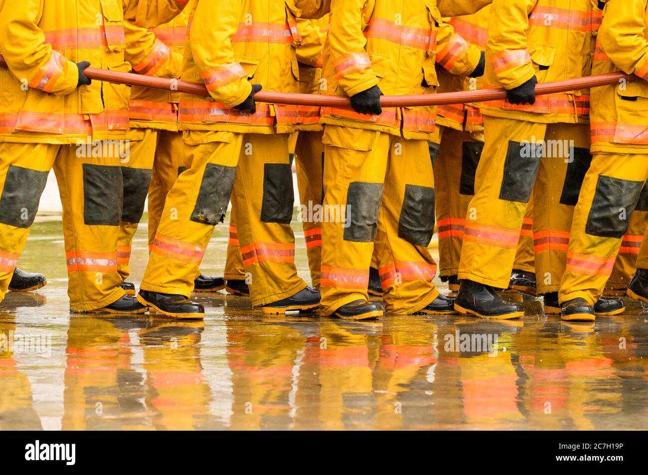 fireman fighting fire flame with water and extinguisher in training ...
